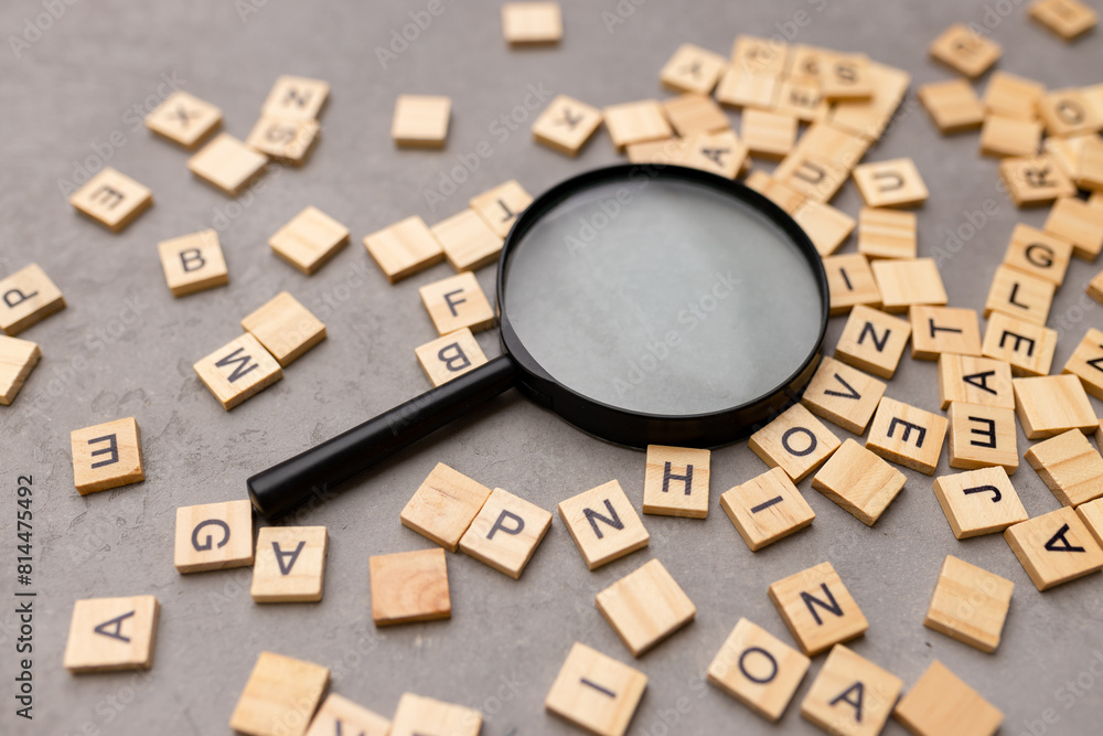 Magnifying glass with many wood letters of English alphabets, learning ...