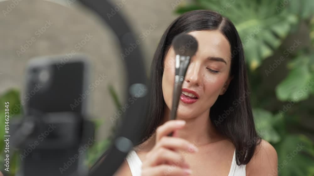 Beautiful content creator making natural beauty and cosmetic tutorial at green plant leave ...