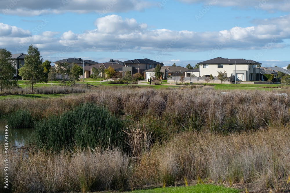 A suburban neighbourhood with many Australian homes faces a large ...
