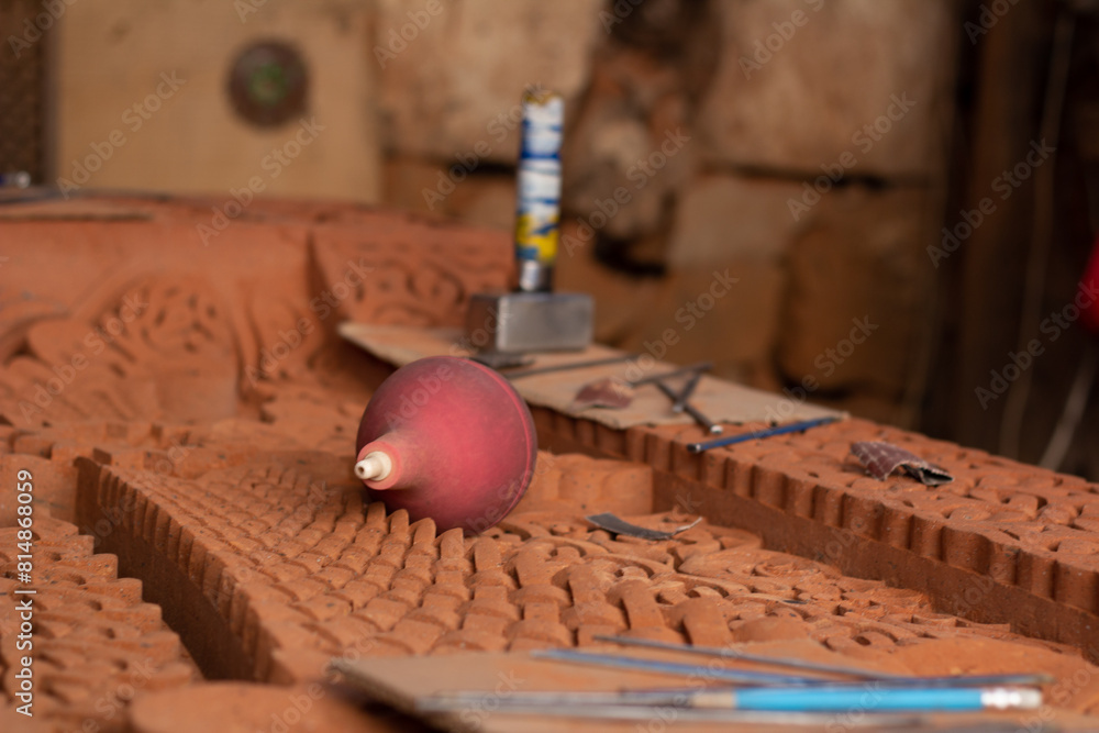Set of work tools, gravers, enema, chisels lies on red brick religious ...