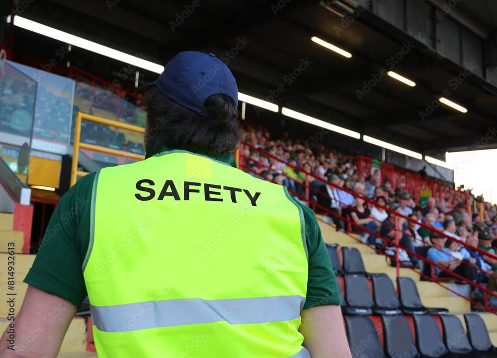 muscular security guard wearing a uniform with the word SAFETY standing ...