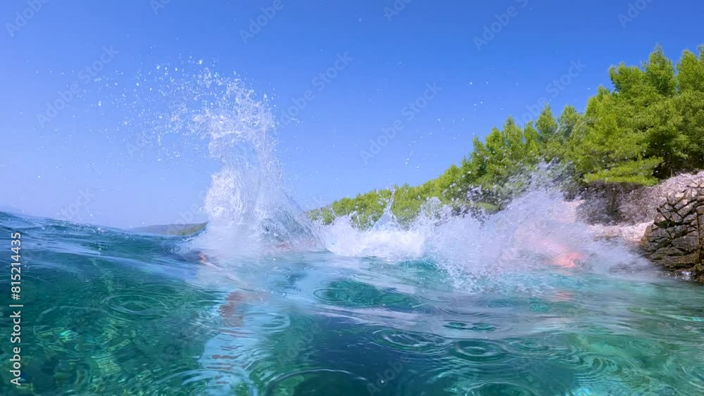 SLOW MOTION: Carefree vacationer jumps head first into crystal clear ...
