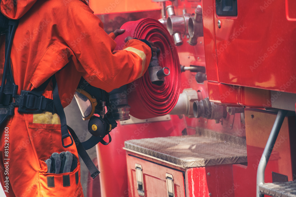 Fireman prepare equipment fighting extinguisher at fire engine truck ...