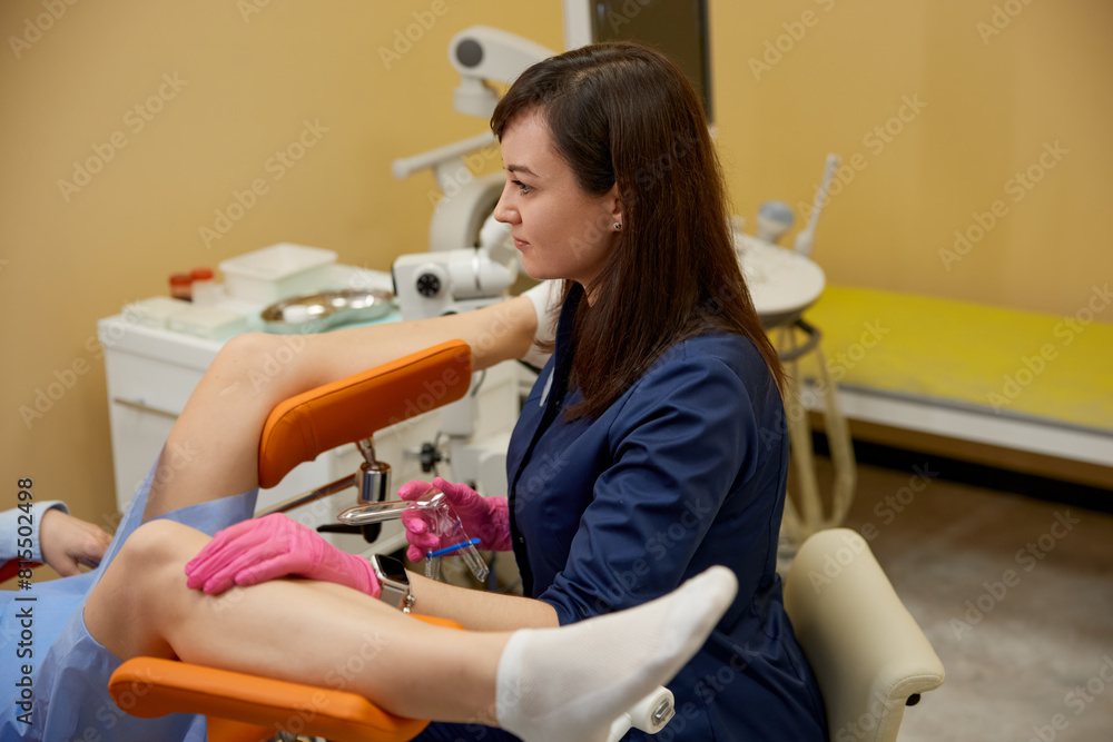 Doctor providing examination of female patient at gynecology chair ...