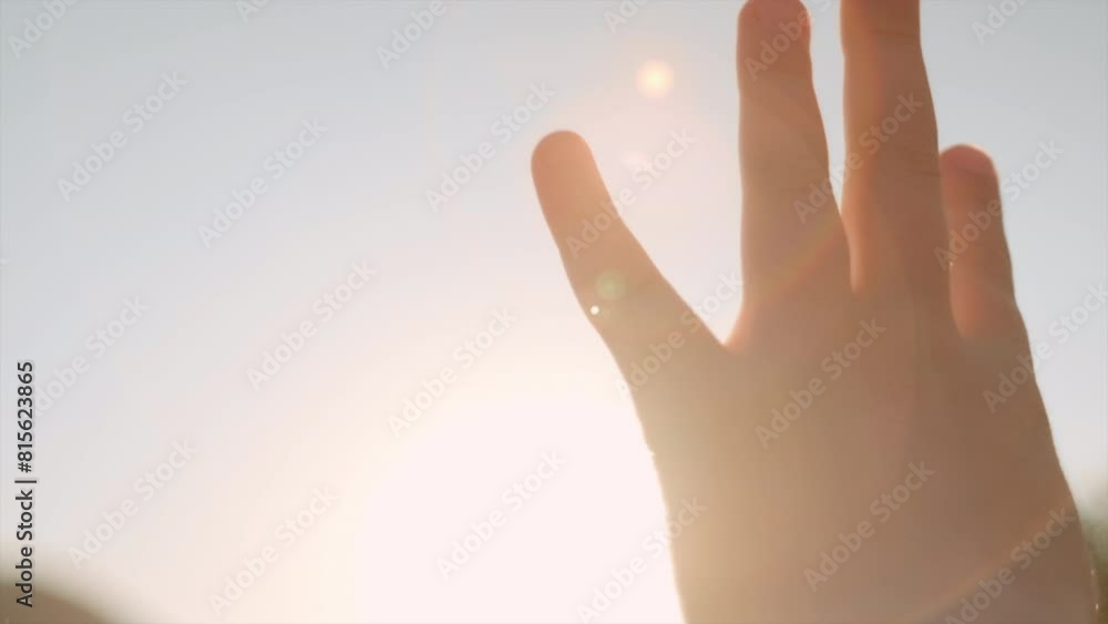 Little girl raising hand over sunset sky, enjoying life and nature ...