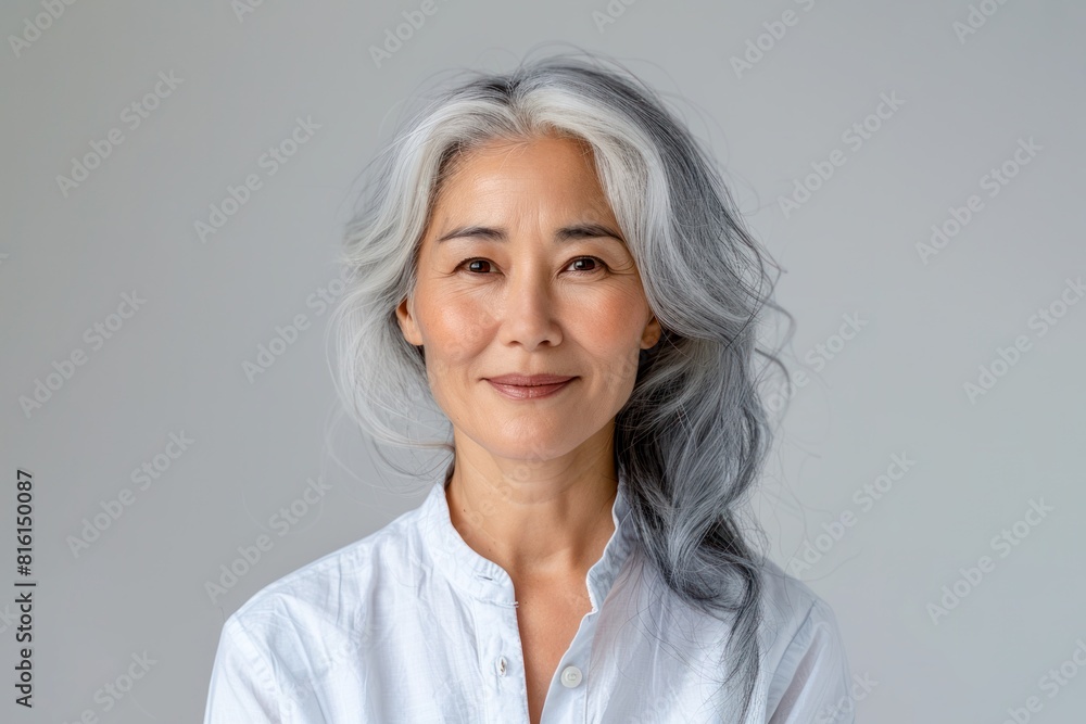 beautiful asian woman with grey hair smiling on studio background ...