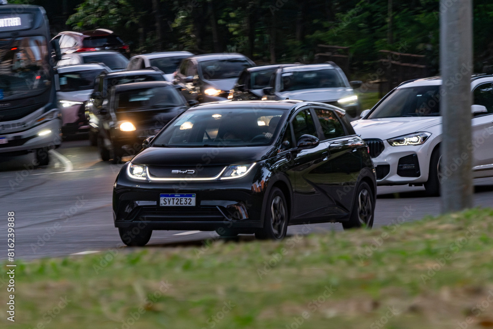 Panning shot of a black BYD Seal driving in city traffic - Electric ...