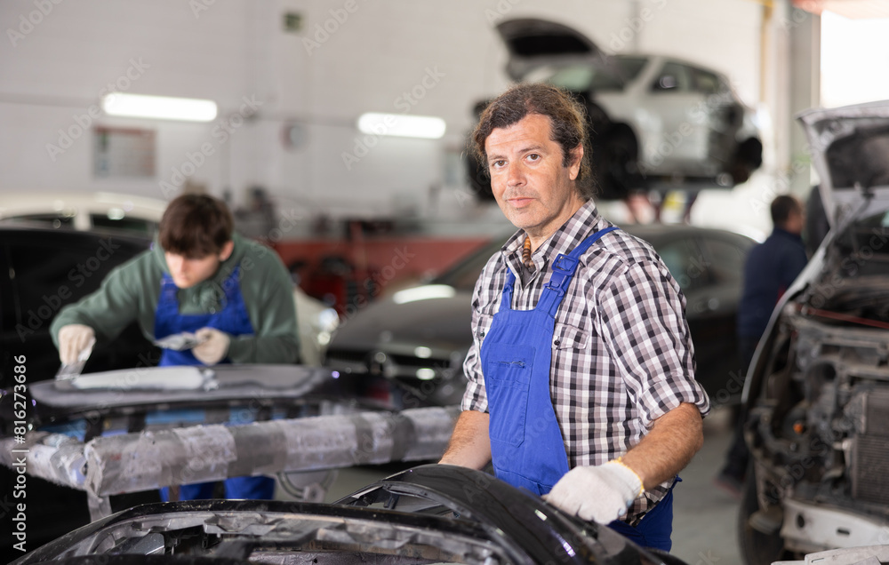 Confident successful middle-aged auto repair workshop owner in casual ...