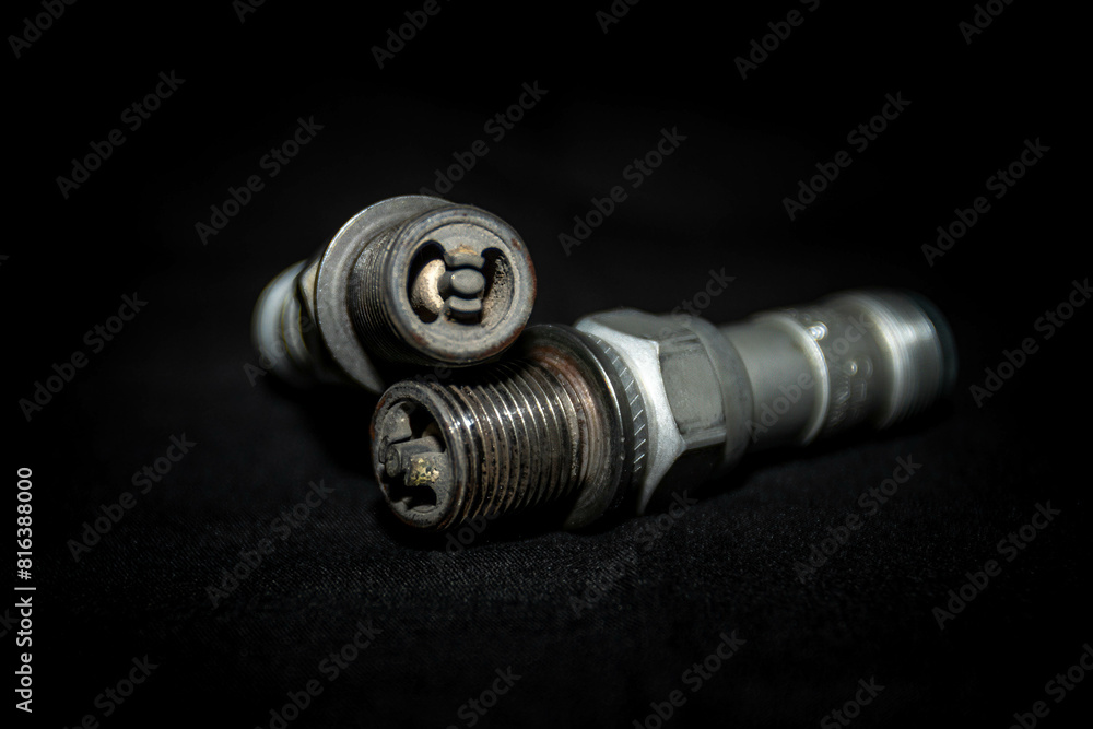 Two spark plugs stacked on black background. Massive electrode type ...