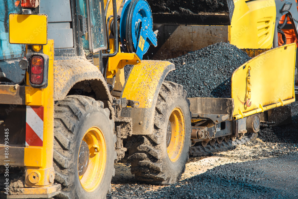 Part of Yellow asphalt paver-filled tarmac laying new road building ...