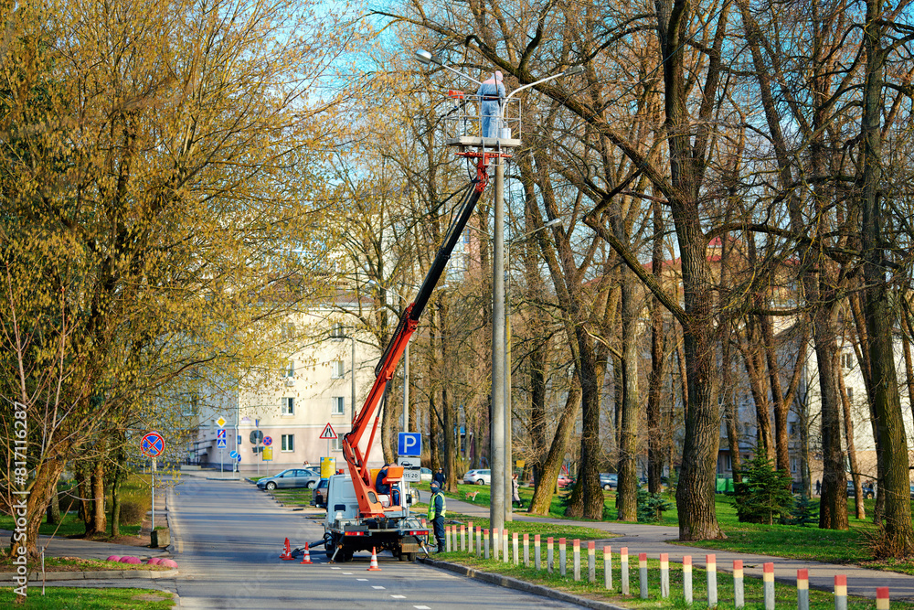 Aerial platform truck, painter at height painting and renew streetlight ...