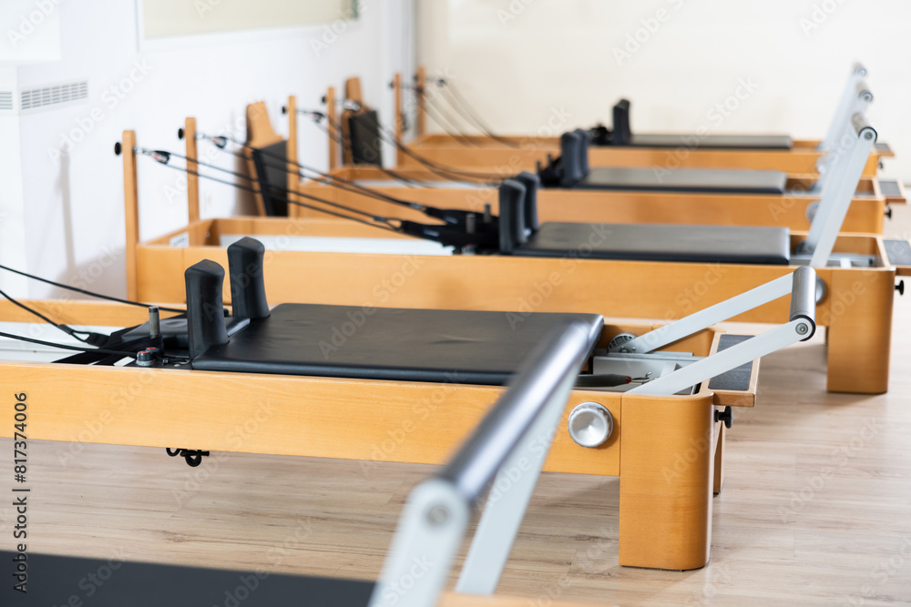 Empty Pilates studio with modern trapeze tables for fitness and ...