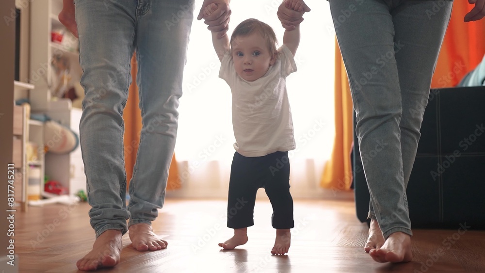 baby takes his first steps. happy family a kid dream concept. parents ...