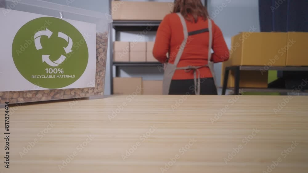 The focus is on a container labeled "100% Recyclable Materials" filled ...