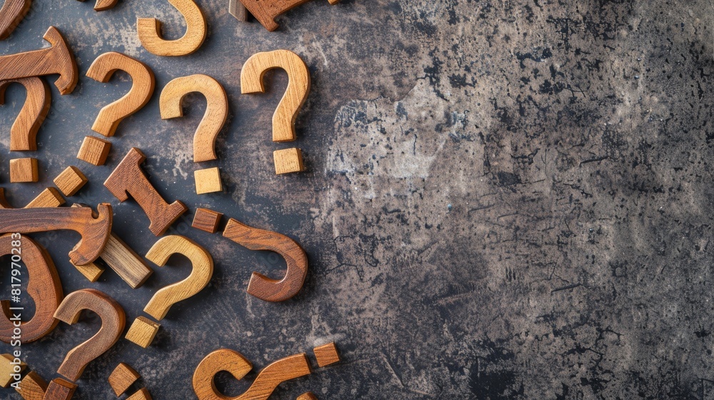 Collection of wooden question mark pieces scattered across a dark ...
