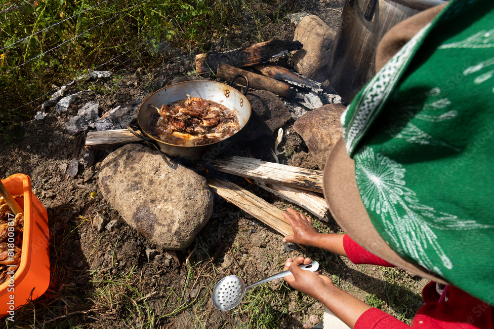 Indigenous woman cooking over firewood with metal pots and frying pan ...