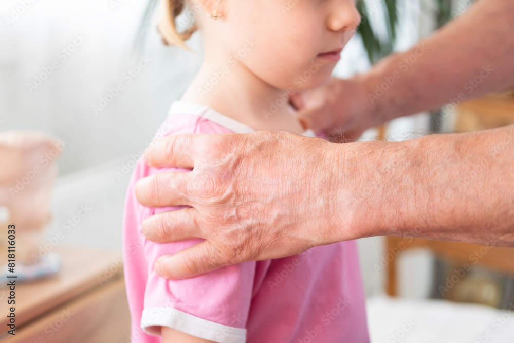 male Orthopedist doctor conducts spinal examination child, young girl ...