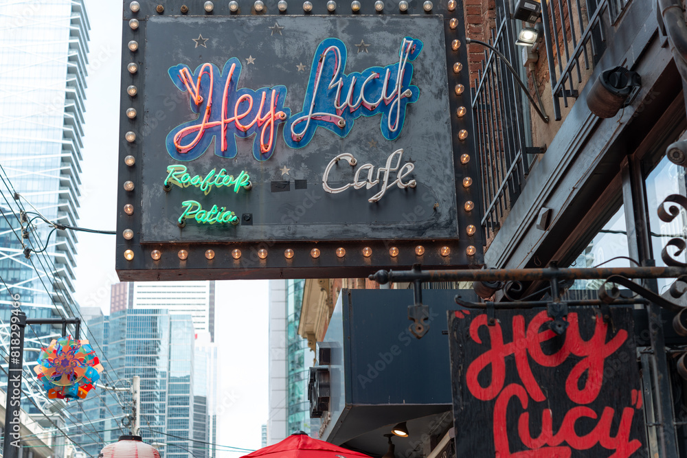 old marquee sign board projecting near entrance to an Italian restaurant named "Hey Lucy" and ...