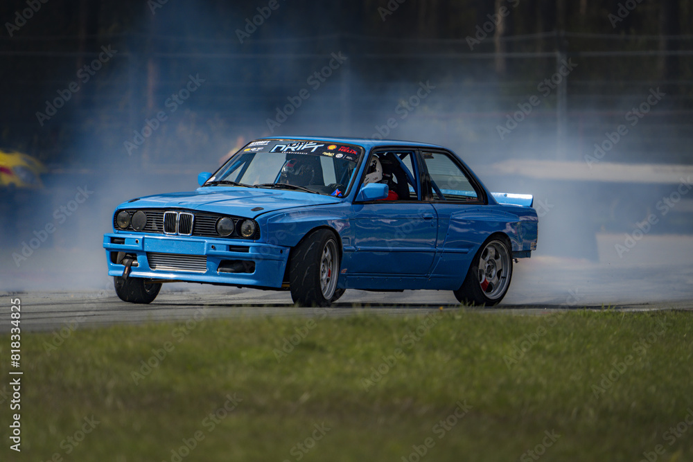 Riga 28-04-2024 Drift A blue car drives down a racetrack, emitting ...
