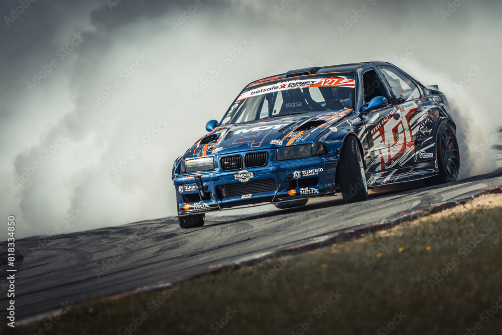 Riga 28-04-2024 Drift A blue car races down the track, its exhaust ...