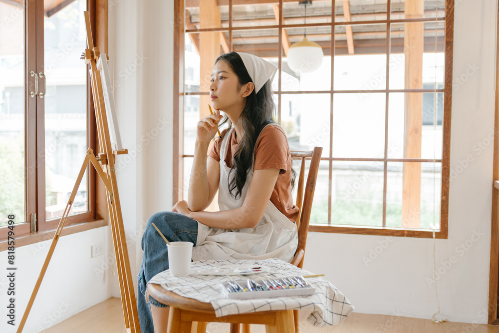 Asian young talented woman artist coloring on painting board in house ...