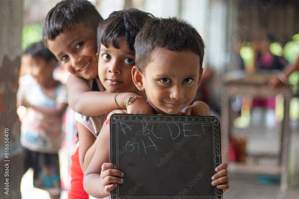 Smiling rural indian school children's holding slate while standing ...