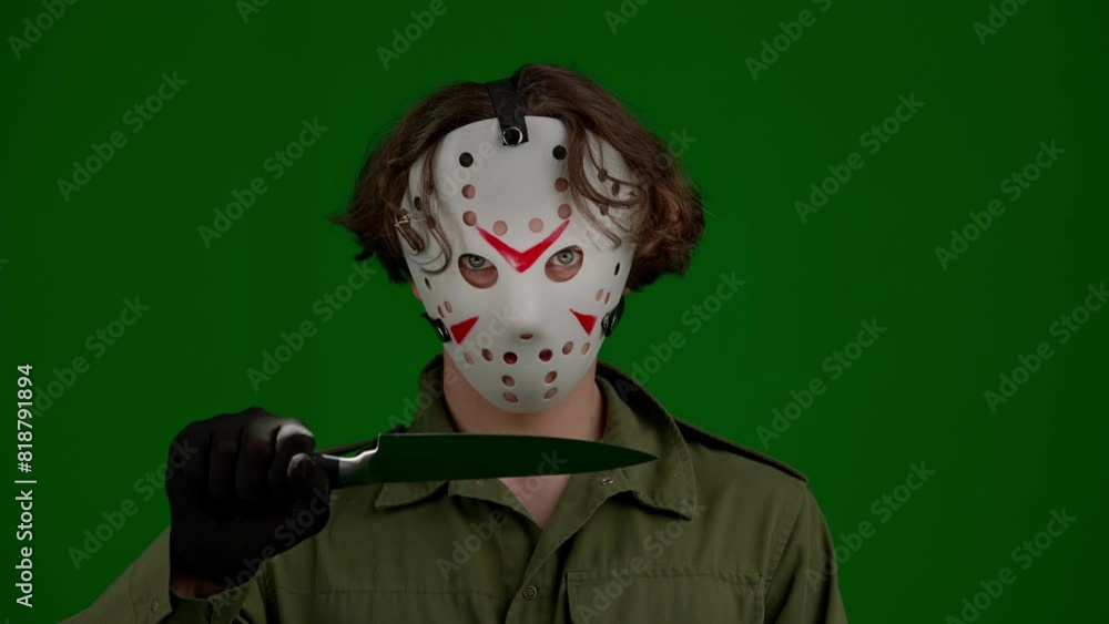 Maniac in hockey mask and coveralls holding a sharp knife ...