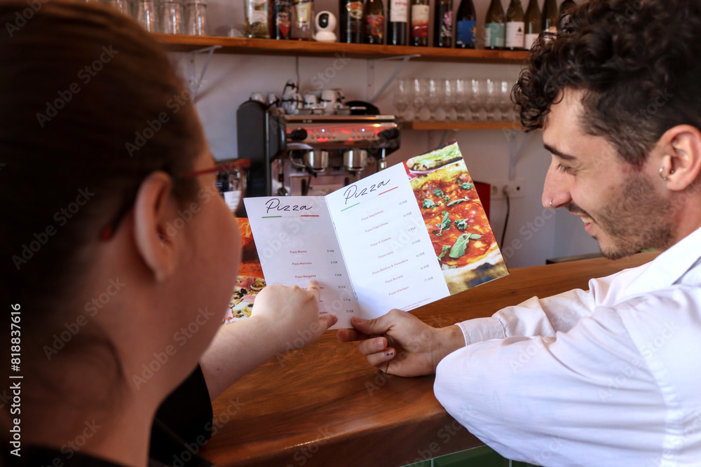 Person smiling choosing food from a menu receives recommendations from ...