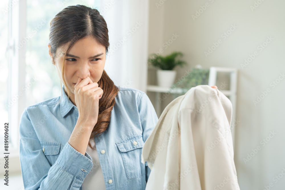 Asian young housewife woman having bad smelling clothes hand holding ...