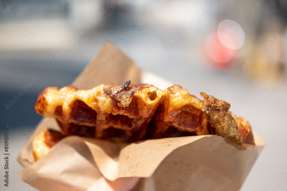 Hand holding Croffle with truffle. It is a hybrid of a croissant and ...