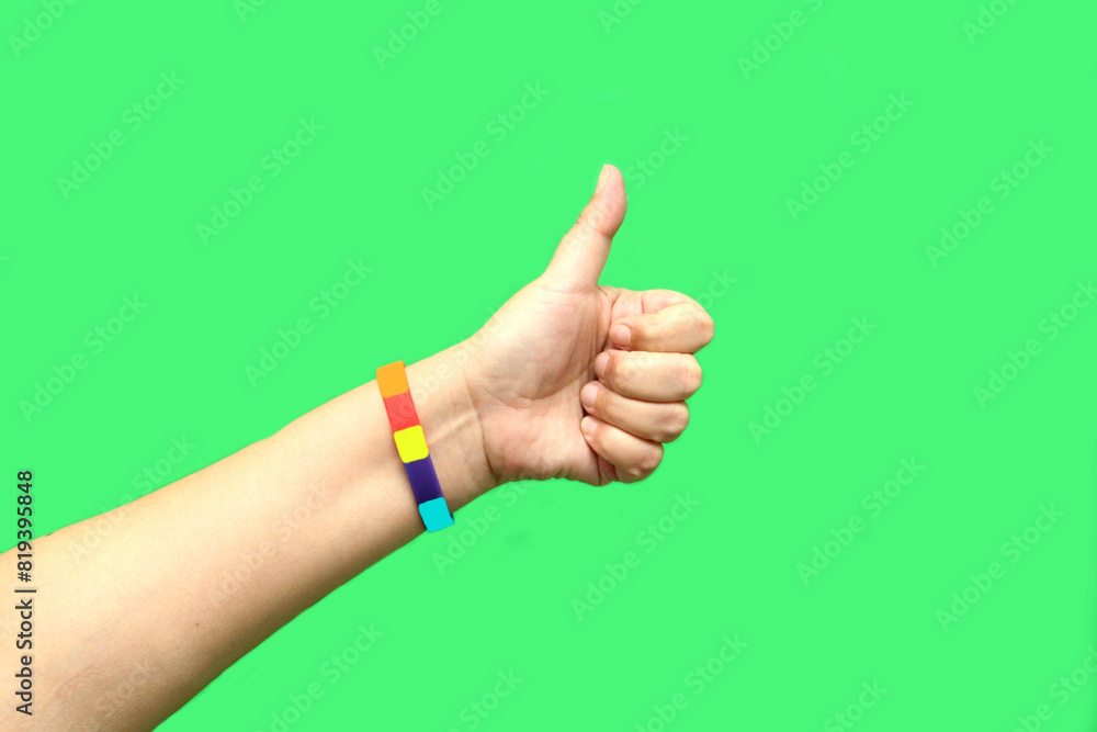 Hand with colorful bracelet as a symbol of the gay flag on the wrist ...