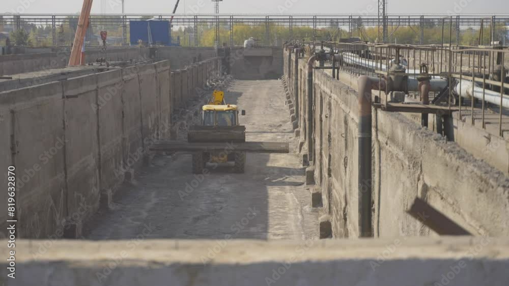 Vidéo Stock Excavator carries concrete beam passing in empty basin of ...