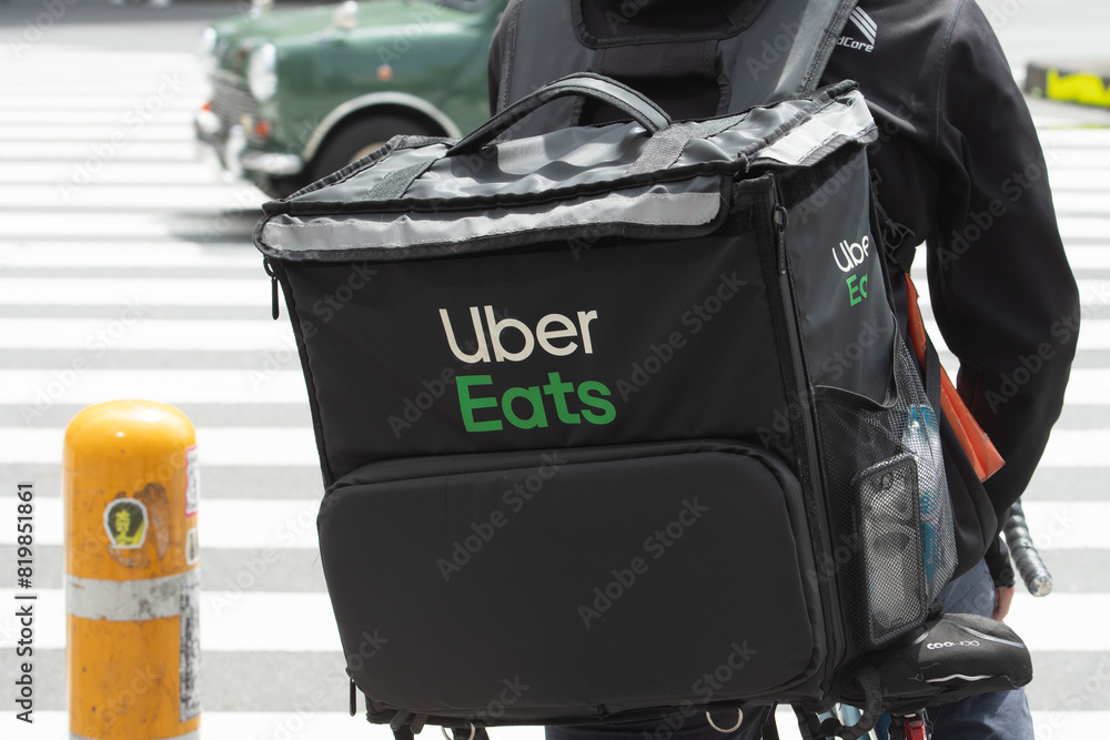 Tokyo, Japan - Aprili 7, 2024 : Uber Eats rider cycling in the street ...
