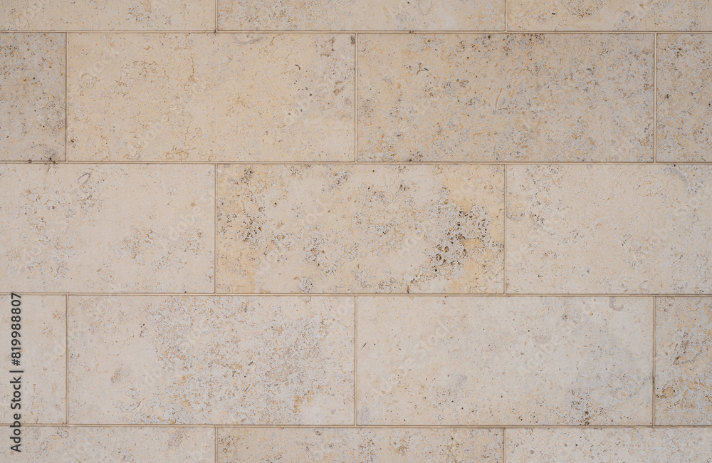 texture of a tiled beige stone wall as background, natural stone wall ...
