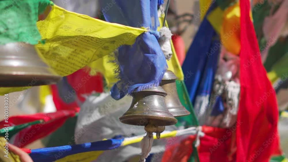 Closeup shot of hand ringing temple bell surrounded by buddhist prayer ...