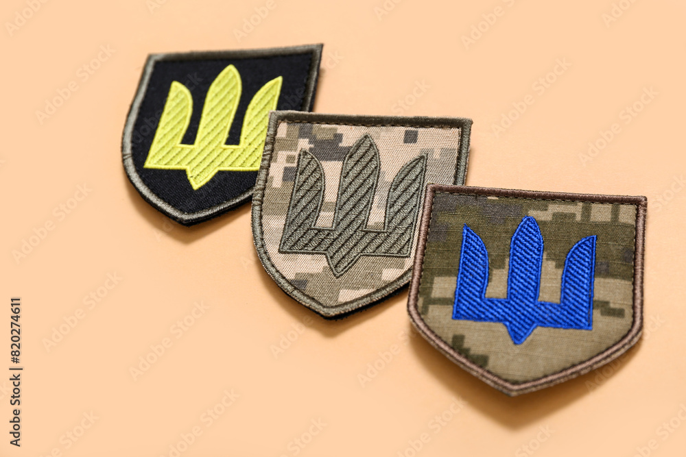 Different military badges of Ukrainian army with trident on beige ...