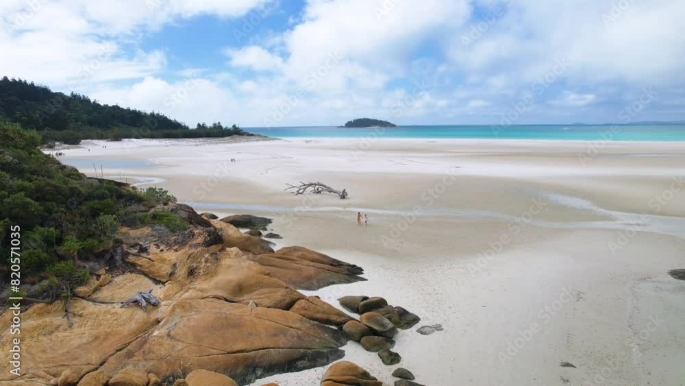 Stationary 4K drone video of a couple running along Whitehaven Beach, a ...