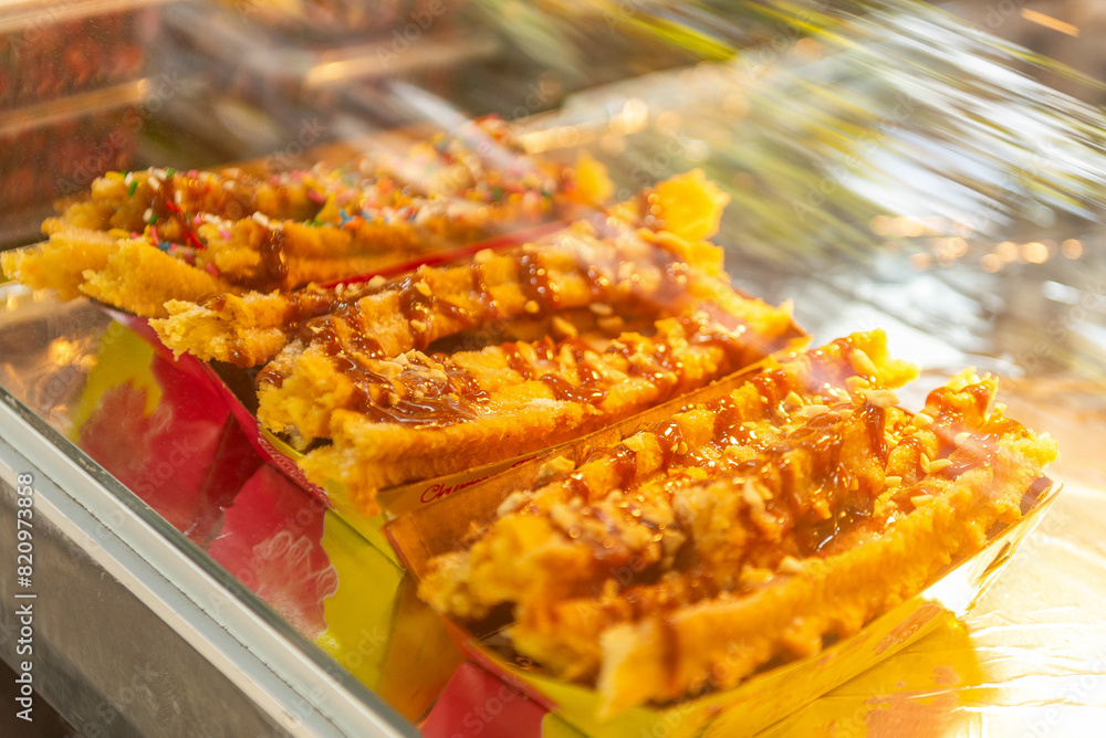Horizontal photograph of several churros de feria with dulce de leche ...