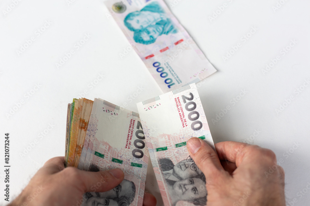 hands counting the new argentine banknotes of 10000, 2000 and 1000 ...