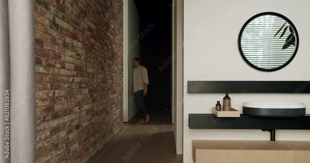 Man Entering a Modern Bathroom with Exposed Brick Wall Design. A young ...