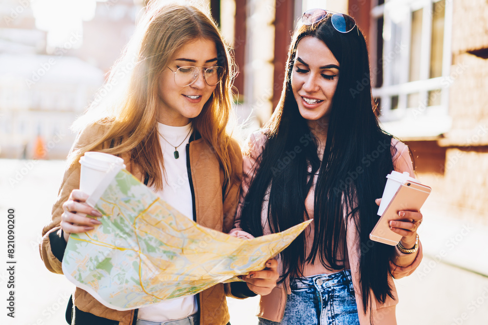 Charming female tourists dressed in stylish casual outfit laughing and ...