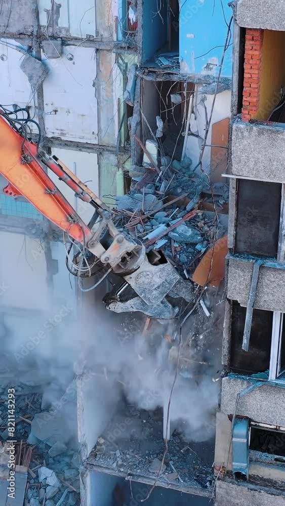 Demolition machine is breaking the floors into pieces and throwing them ...