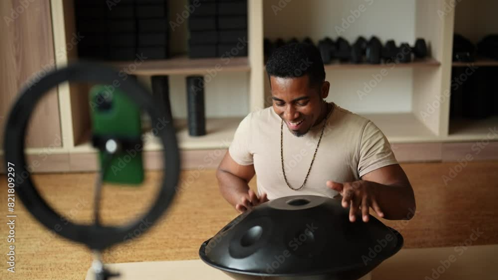 Joyful African male blogger practicing native music traditional ...