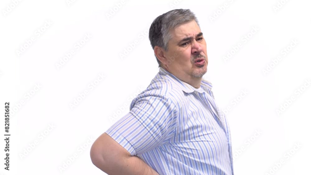A man winces in pain, holding his lower back. Symptom of ...