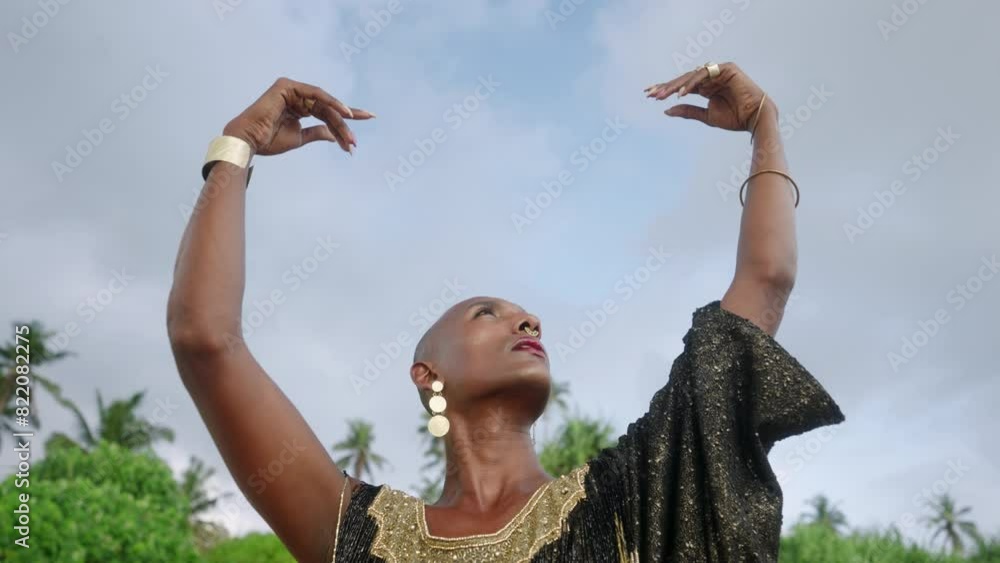 Androgynous person of color in luxury dress, feminine makeup raises ...