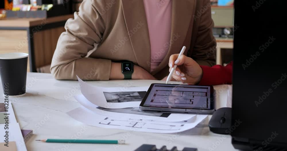 Architects discussing layout on digital tablet, focusing on floor plan ...