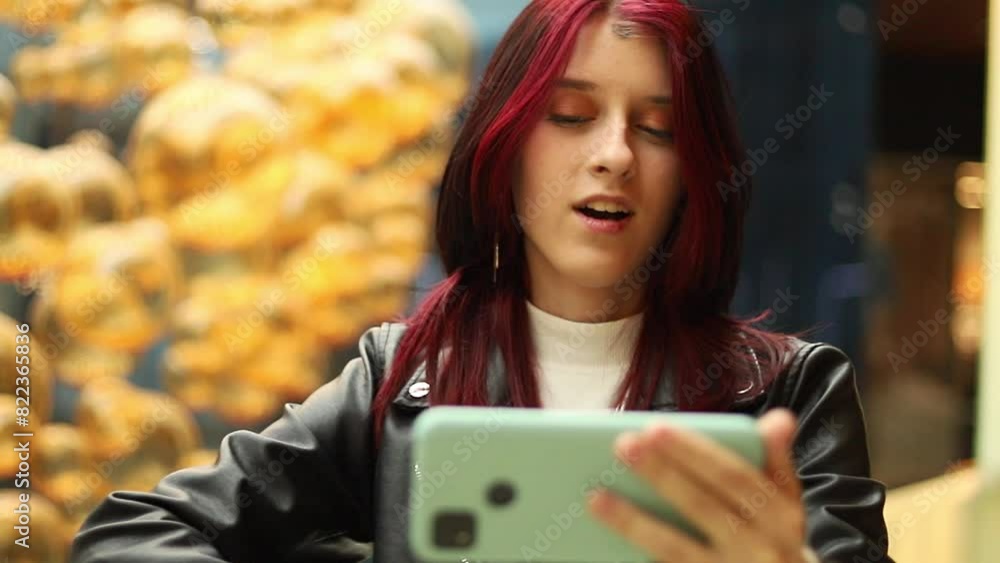 A young girl talks on a video call with a smartphone in a modern ...