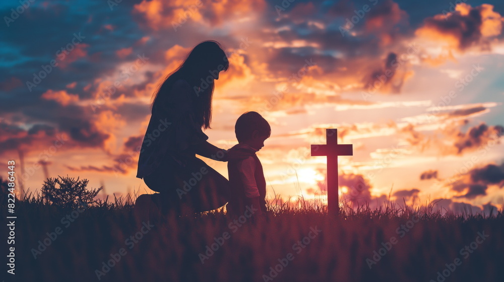 Silhouette of mother and child kneeling in prayer together, side view ...