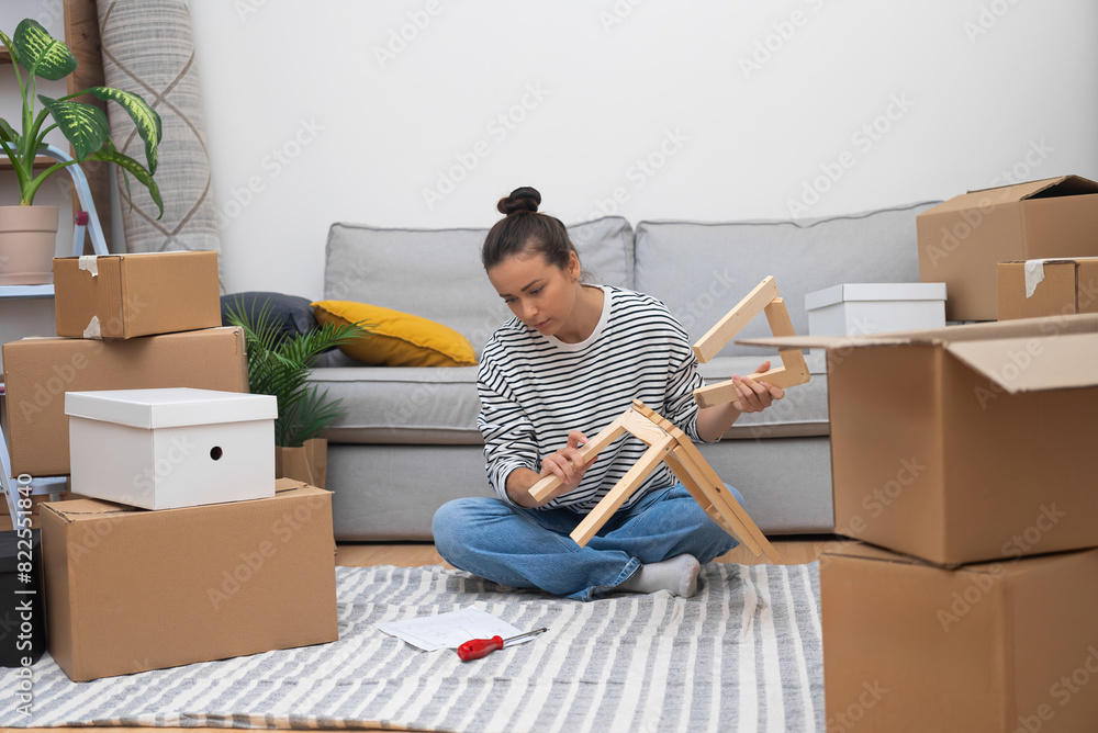 Rental Comfort: Woman tenant sits on the floor, assembling self ...