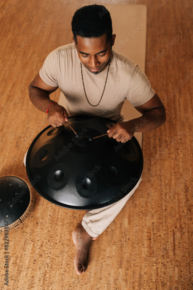 Vertical top view of relaxed black male playing ethnic native music on ...